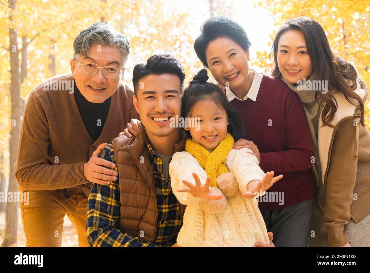 Happy family of five autumn walk ginkgo Lin Stock Photo - Alamy