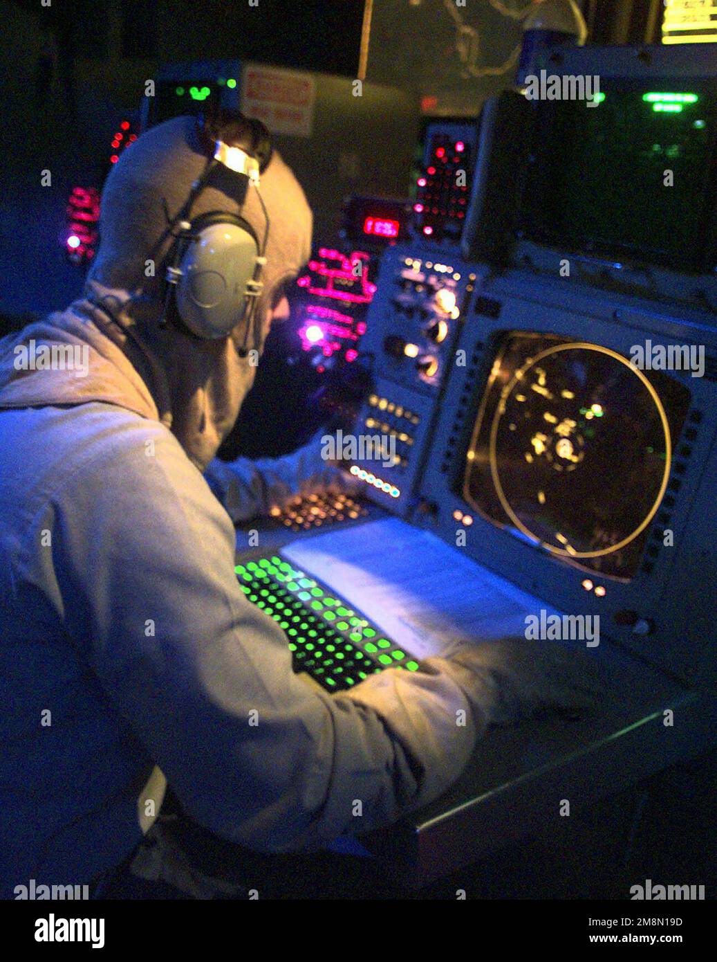 A US Navy Sailor sits at a radar terminal in the Forrestal Class ...