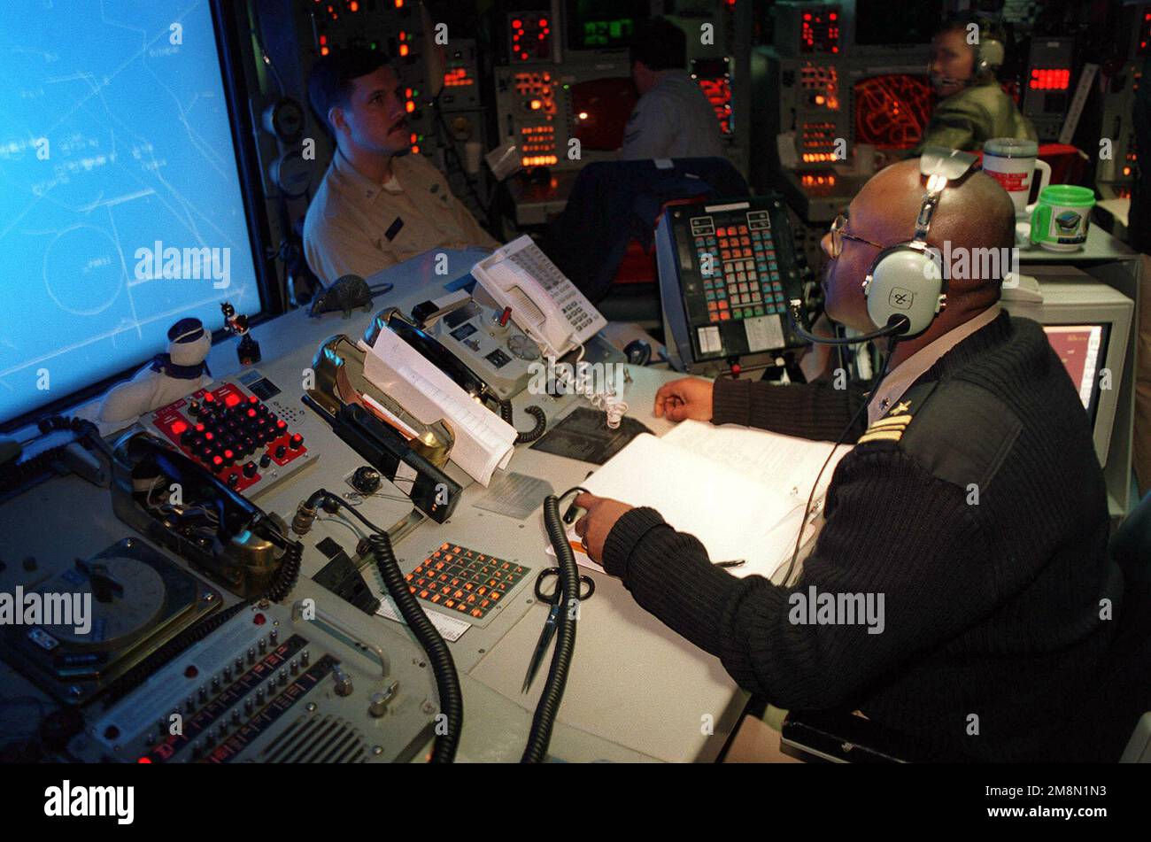 LCDR Thomas McDowell, assistant combat officer, monitors a combat ...