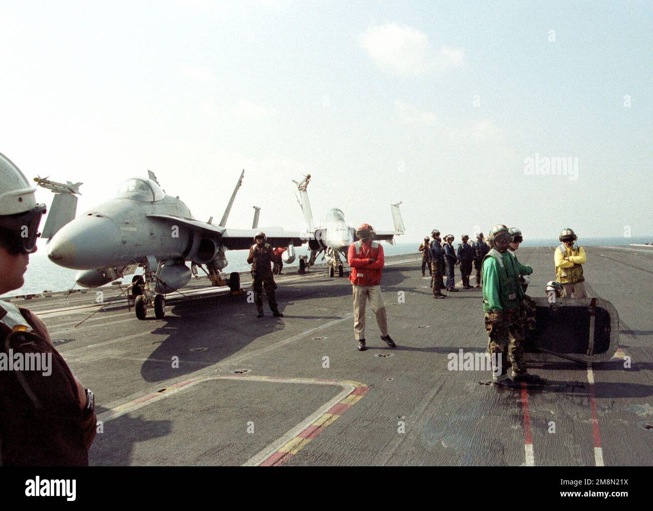 US Navy flight deck personnel await the next launch/recovery cycle ...