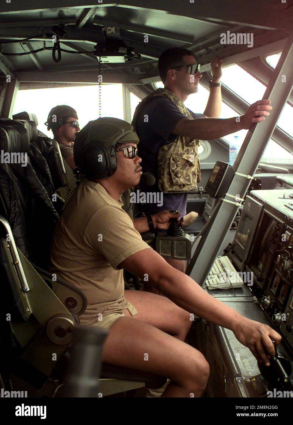 US Navy Boatswain's Mate Second Class Rubin Davilla stears a Navy Mark ...