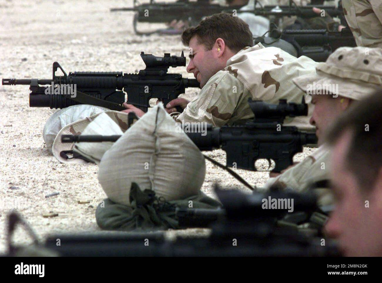 A US Navy SEAL (Third from front), from SEAL Team 8, shoots a Colt 5.5 ...