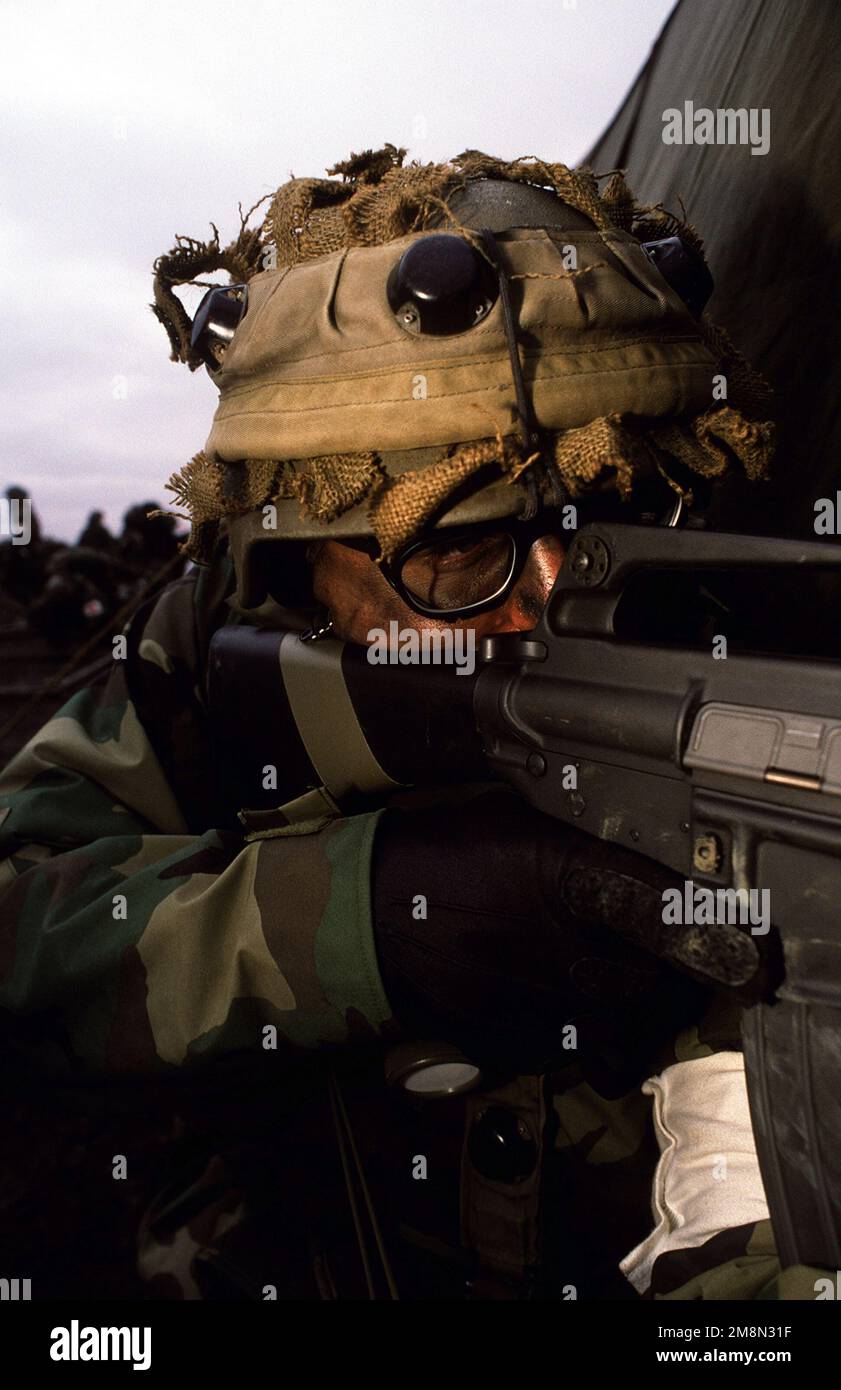 An armed security guard checks his field of fire as deployment ...