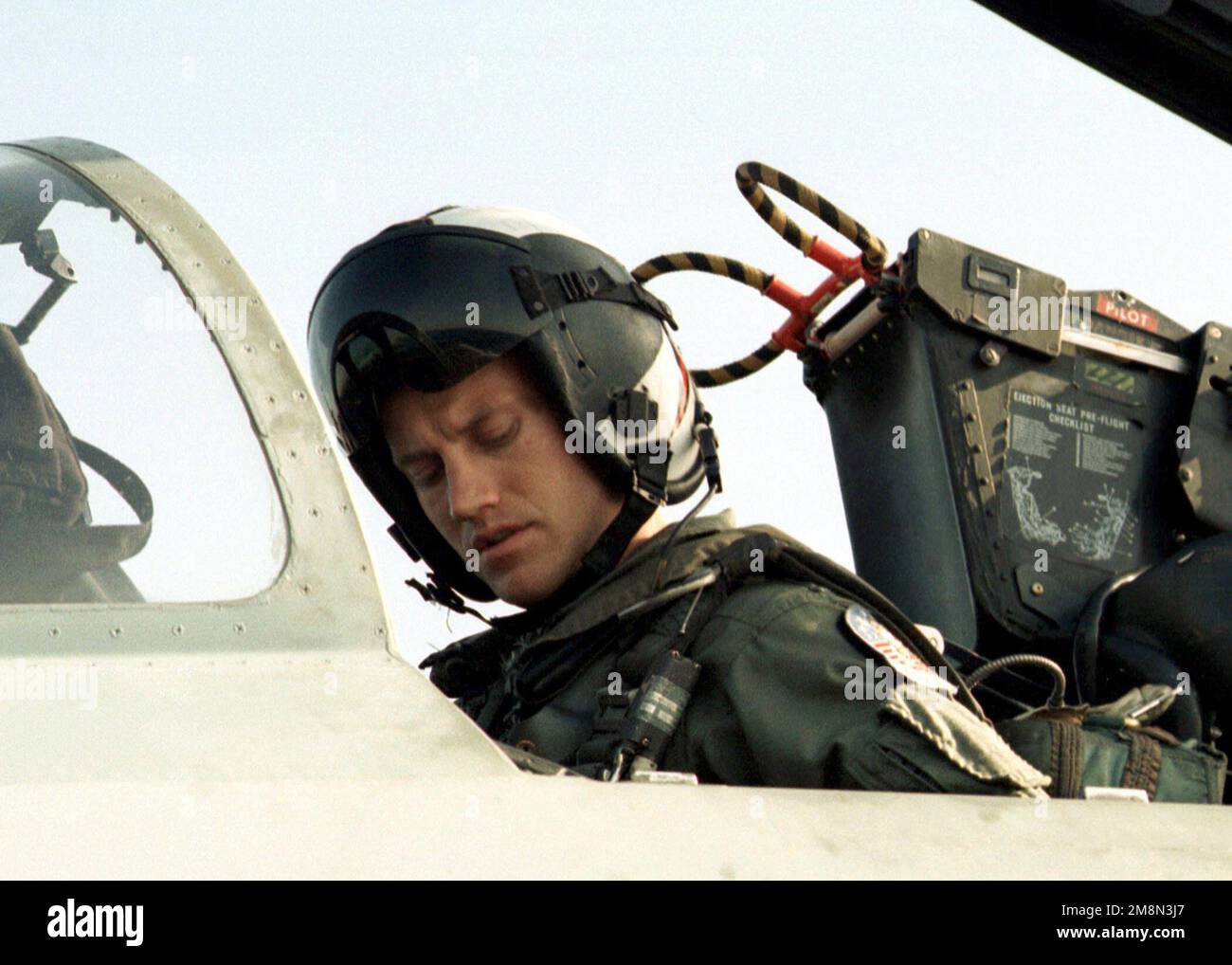 US Navy Lieutenant (LT) Chris Adams finishes strapping into his F-14 ...