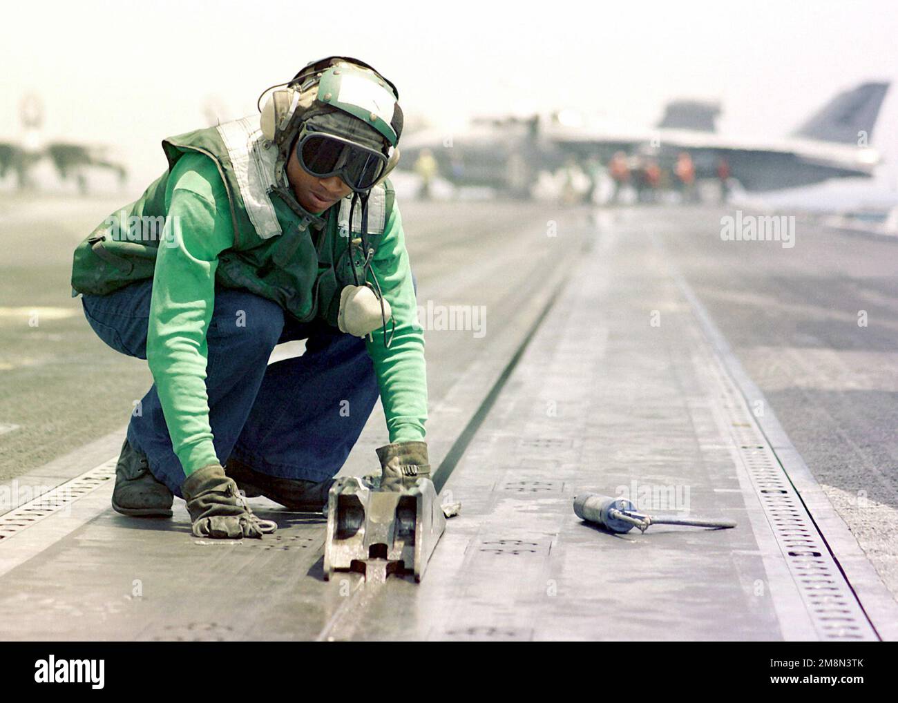 US Navy Aviation Boatswain's Mate 3rd Class (AB3) Peter Duncan cleans ...