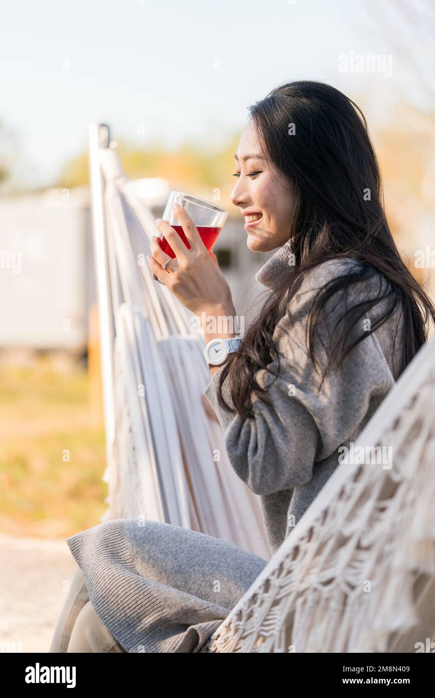 Young woman sitting in a hammock to drink Stock Photo - Alamy