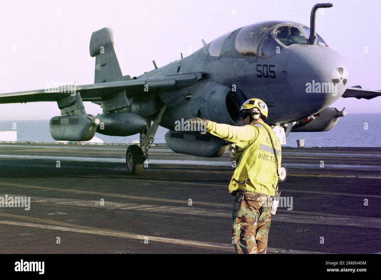 A US Navy aircraft handler guides an EA-6B Prowler from Tactical ...
