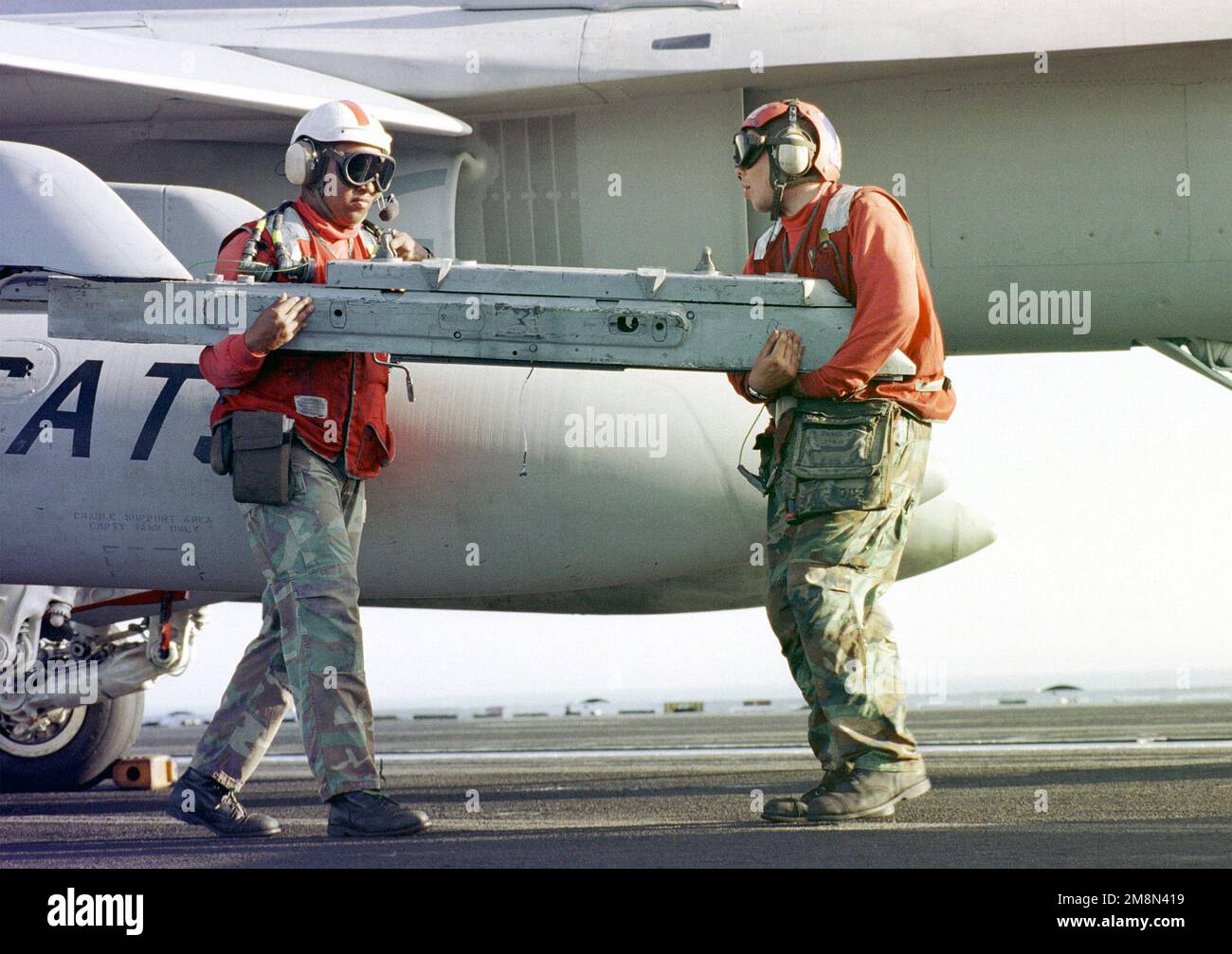 US Navy Aviation Ordinanceman Second Class (AO2) Nigel Reece (left) and ...