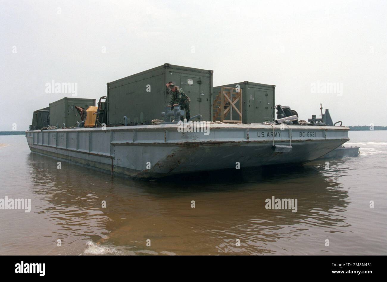A US Army cargo barge, loaded with the Marine Corps' connex boxes ...
