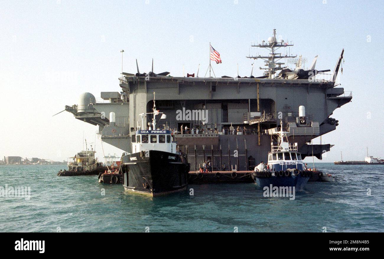 Small boats tie up at the stern of the nuclear powered aircraft carrier ...