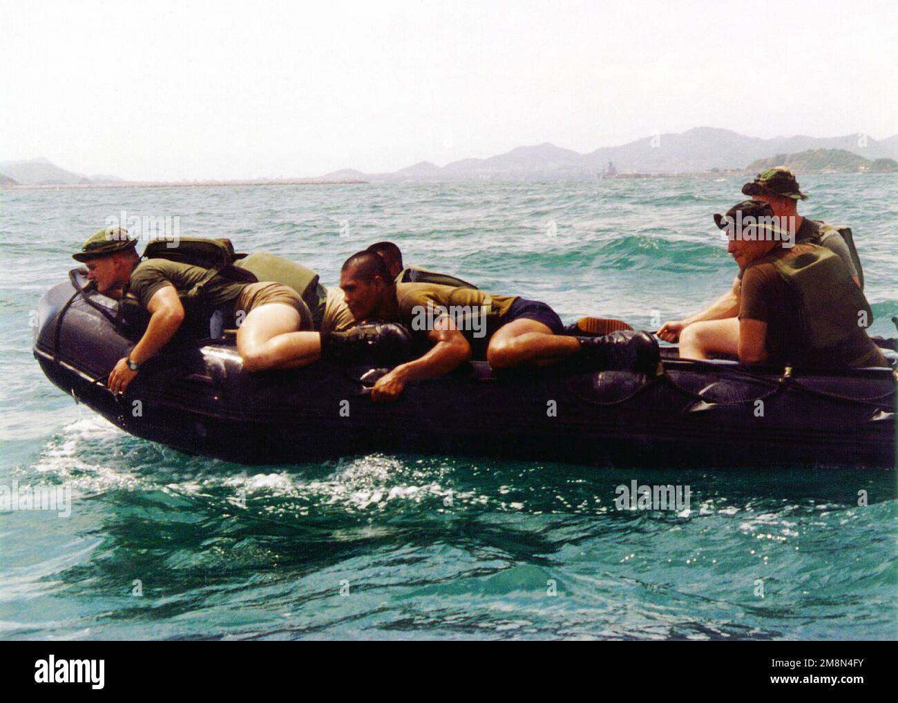 Marines from the US and Thailand hug the side of a combat rigid raider ...