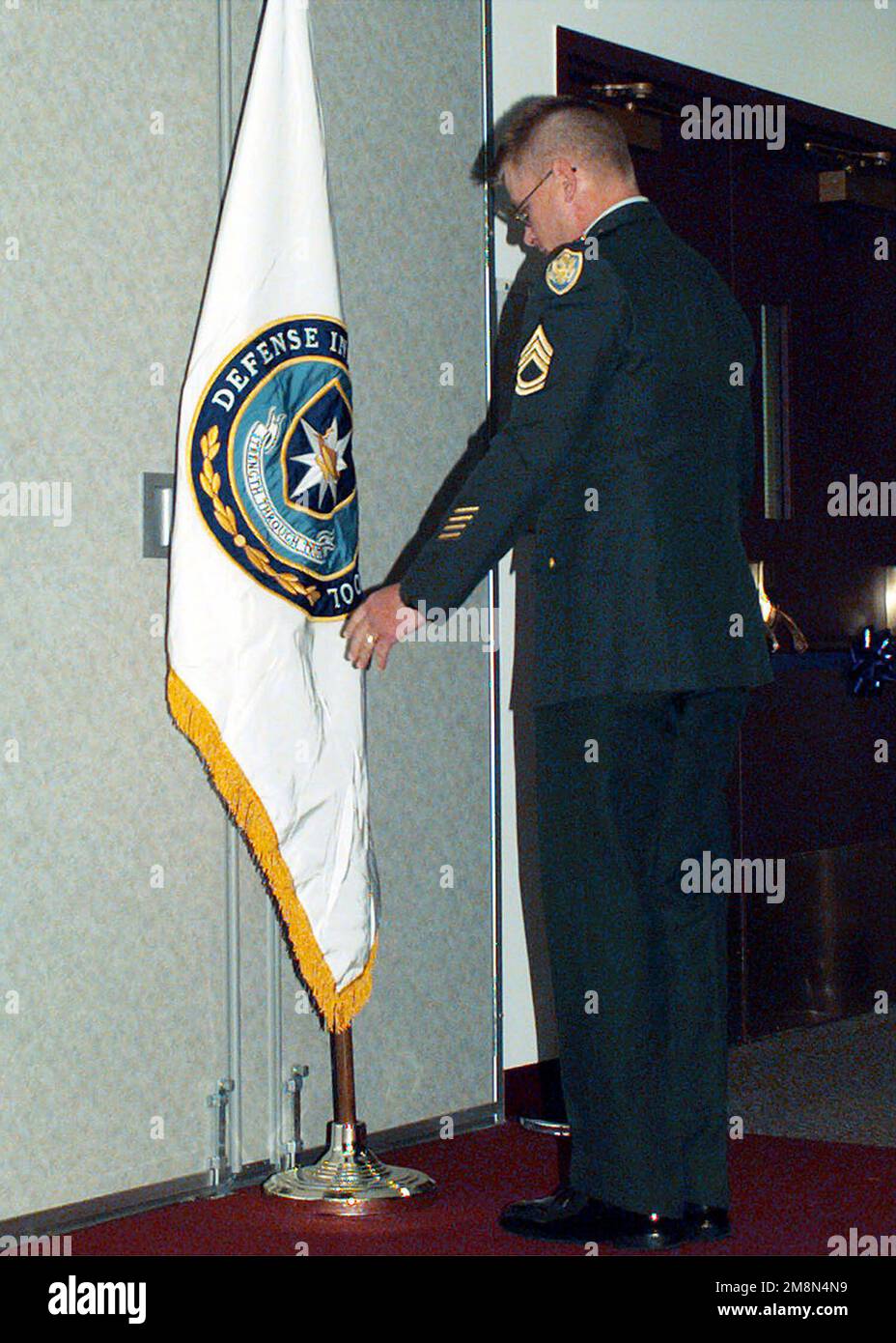 SFC Milsted places the new Defense Information School flag into the ...