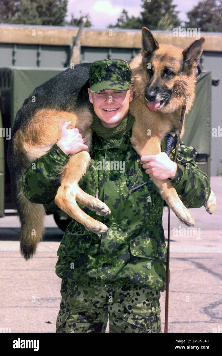 A member of the Danish Guard Dog team poses with their German Sheppard ...