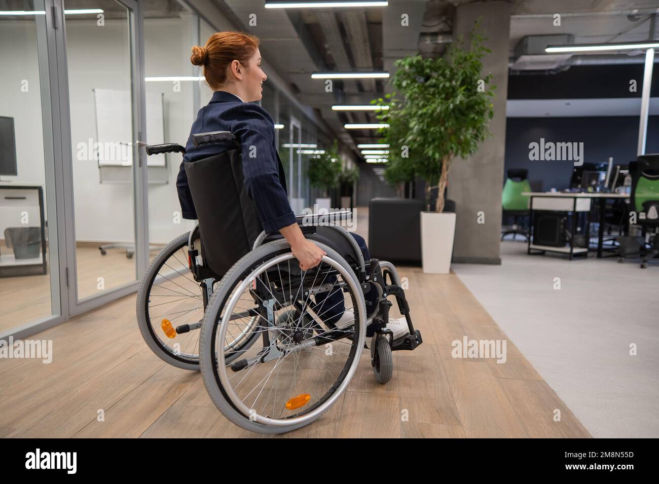 Caucasian woman wheelchair in open space office Stock Photo - Alamy