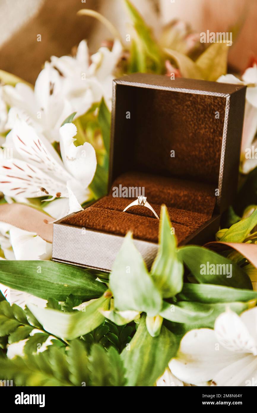 Wedding ring in a box close-up, gold ring with a diamond in flowers ...