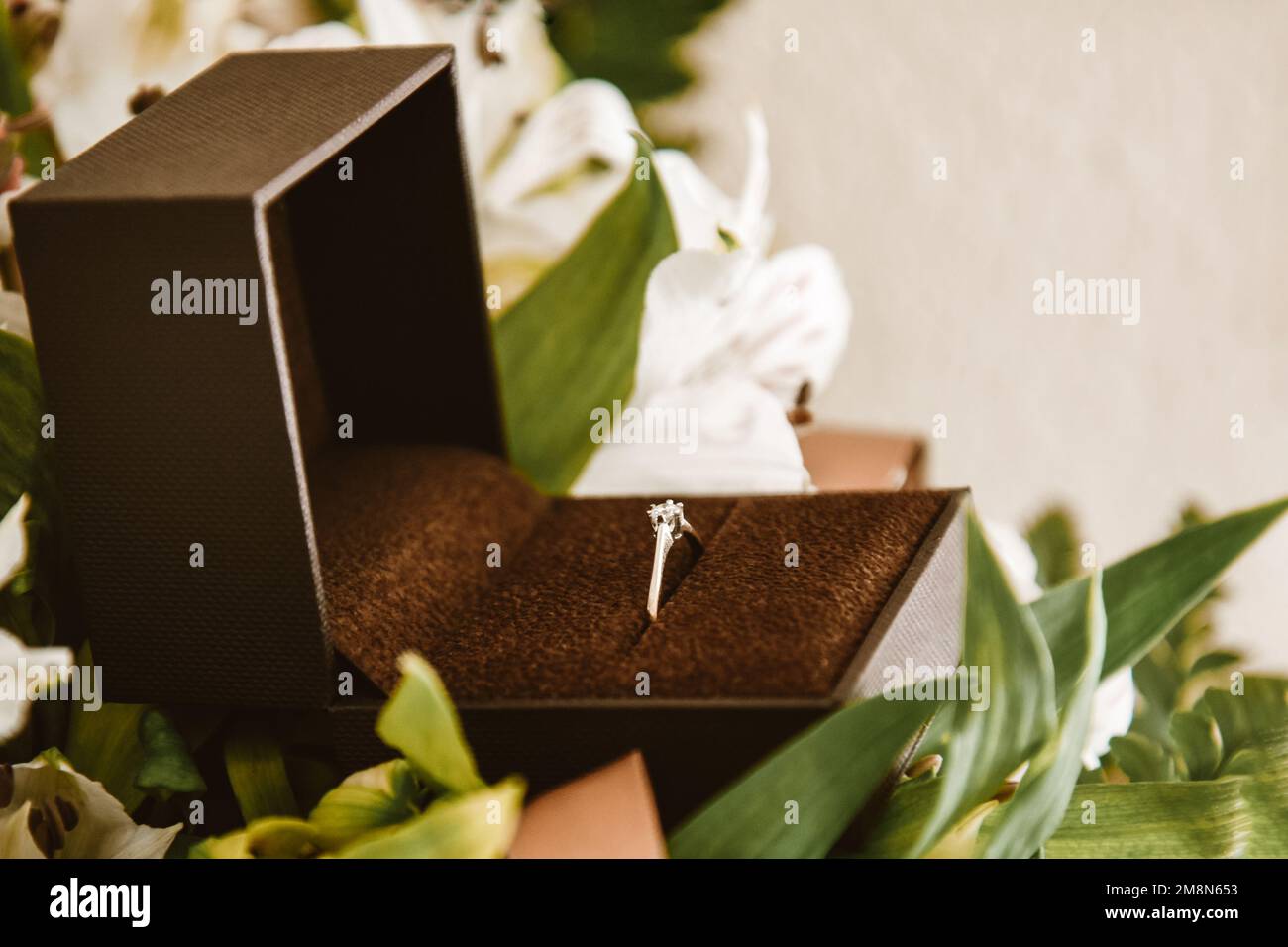Wedding ring in a box close-up, gold ring with a diamond in flowers ...