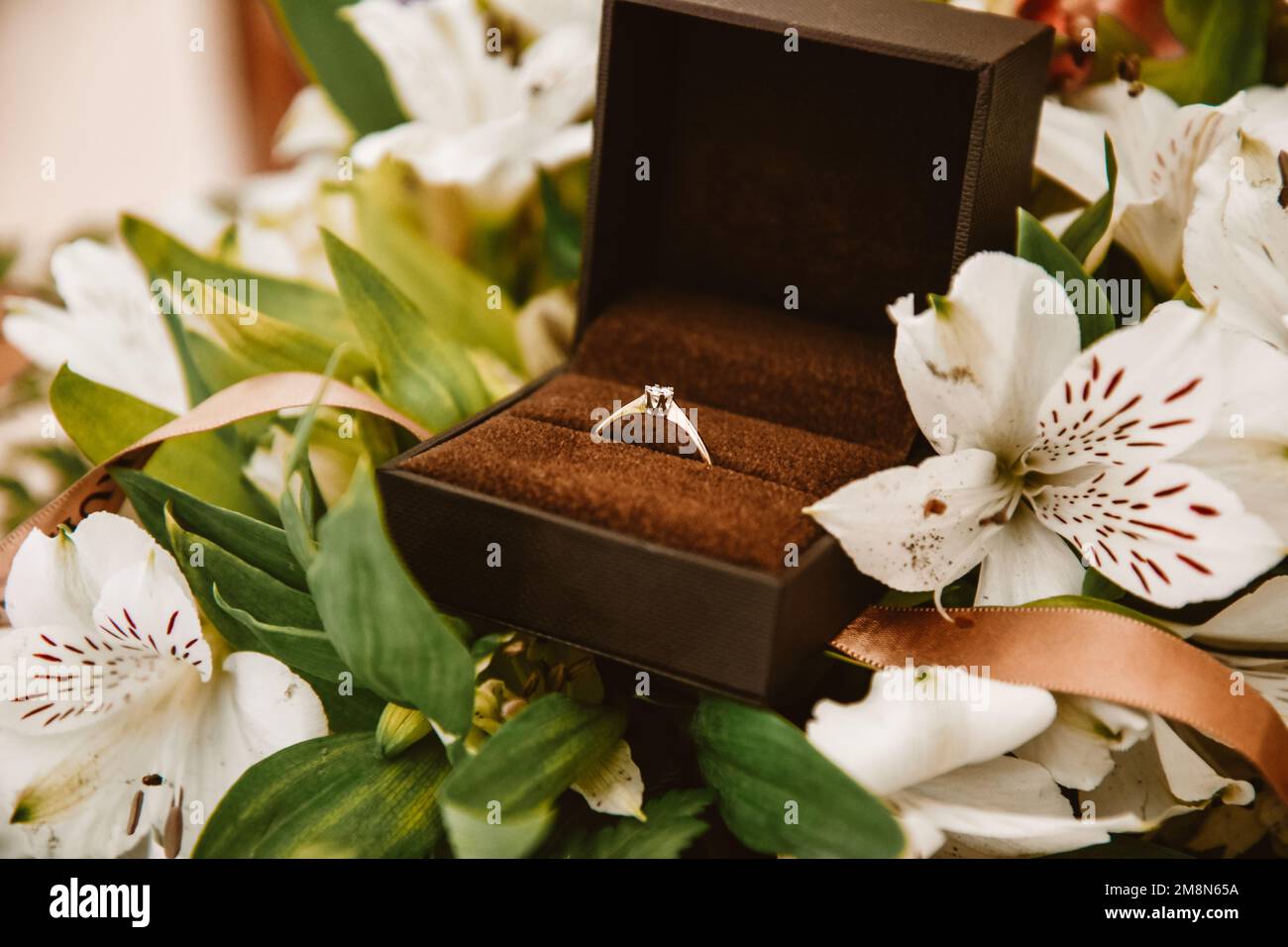Wedding ring in a box close-up, gold ring with a diamond in flowers ...