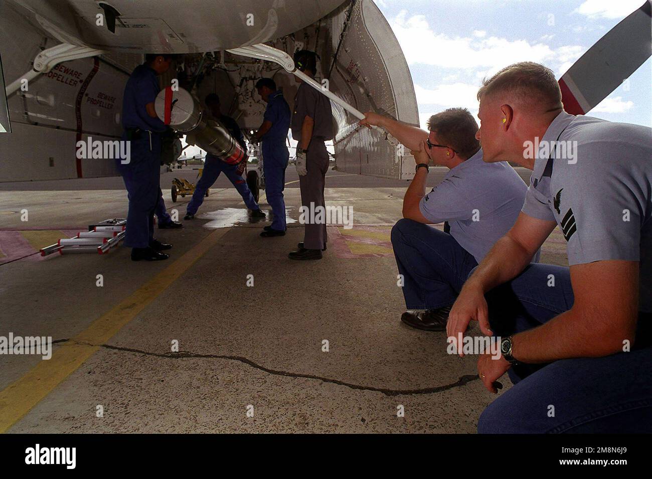 Japanese aircrewmen load a MK-46 air launched torpedo into the bomb bay ...