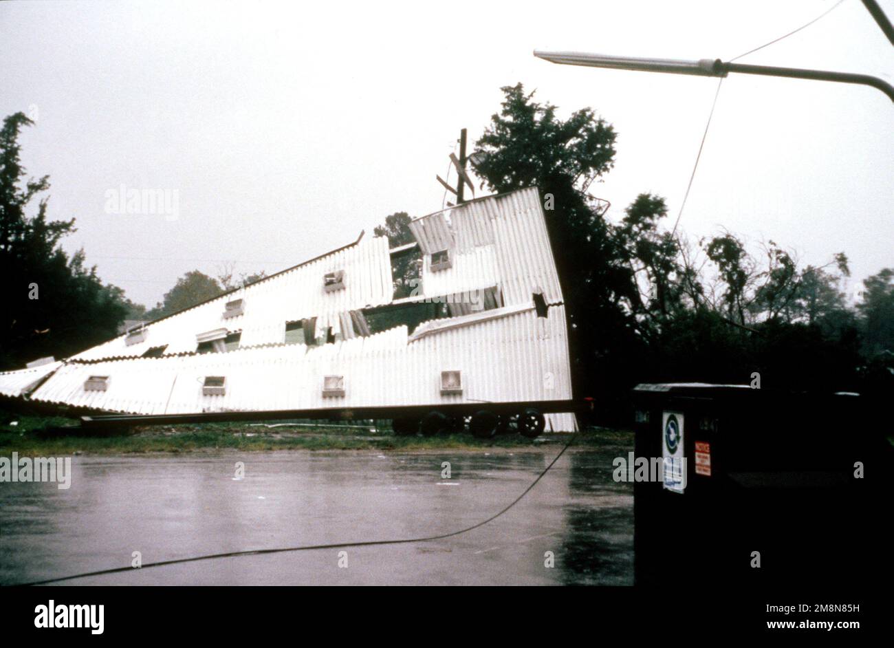 The damaged rooftop of a convenience store and downed electrical power ...