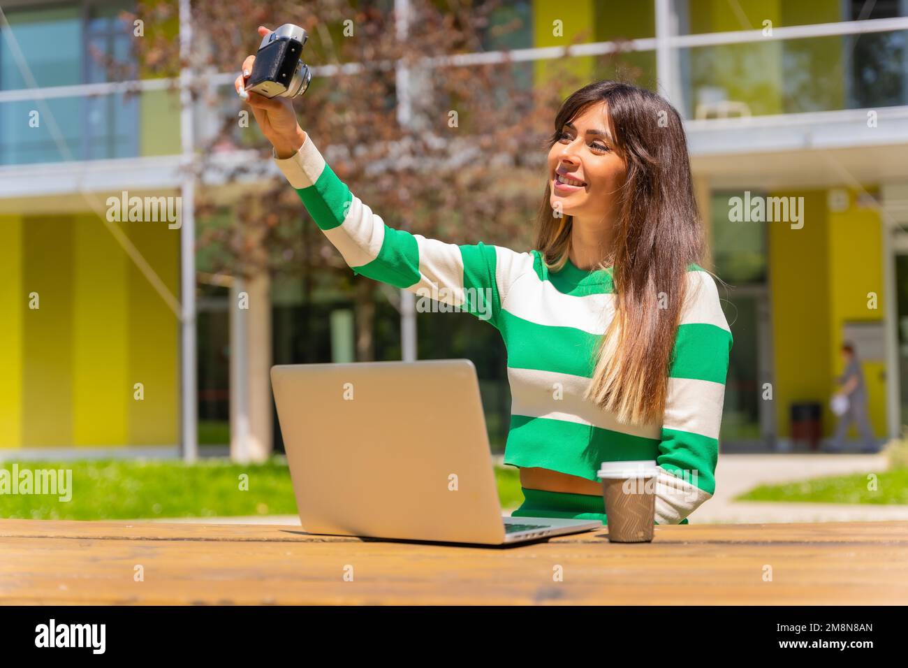 Portrait of a caucasian girl working with a computer in nature, taking ...
