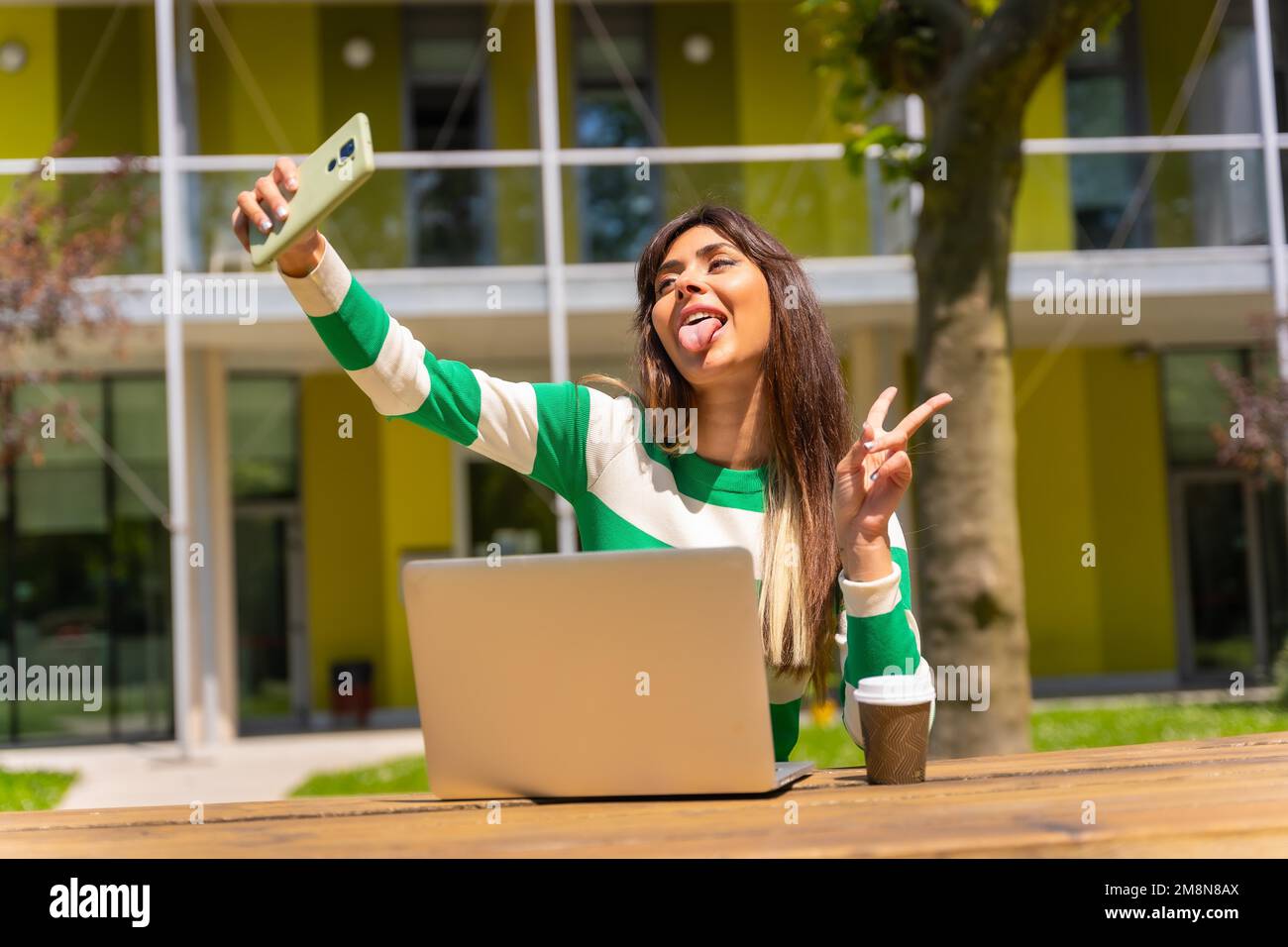 Portrait of a caucasian girl working with a computer in nature, taking ...