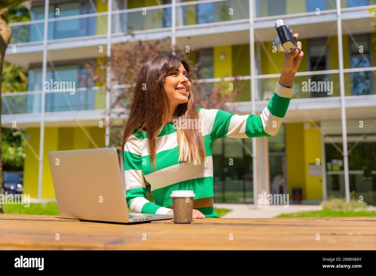 Portrait of a caucasian girl working with a computer in nature, taking ...