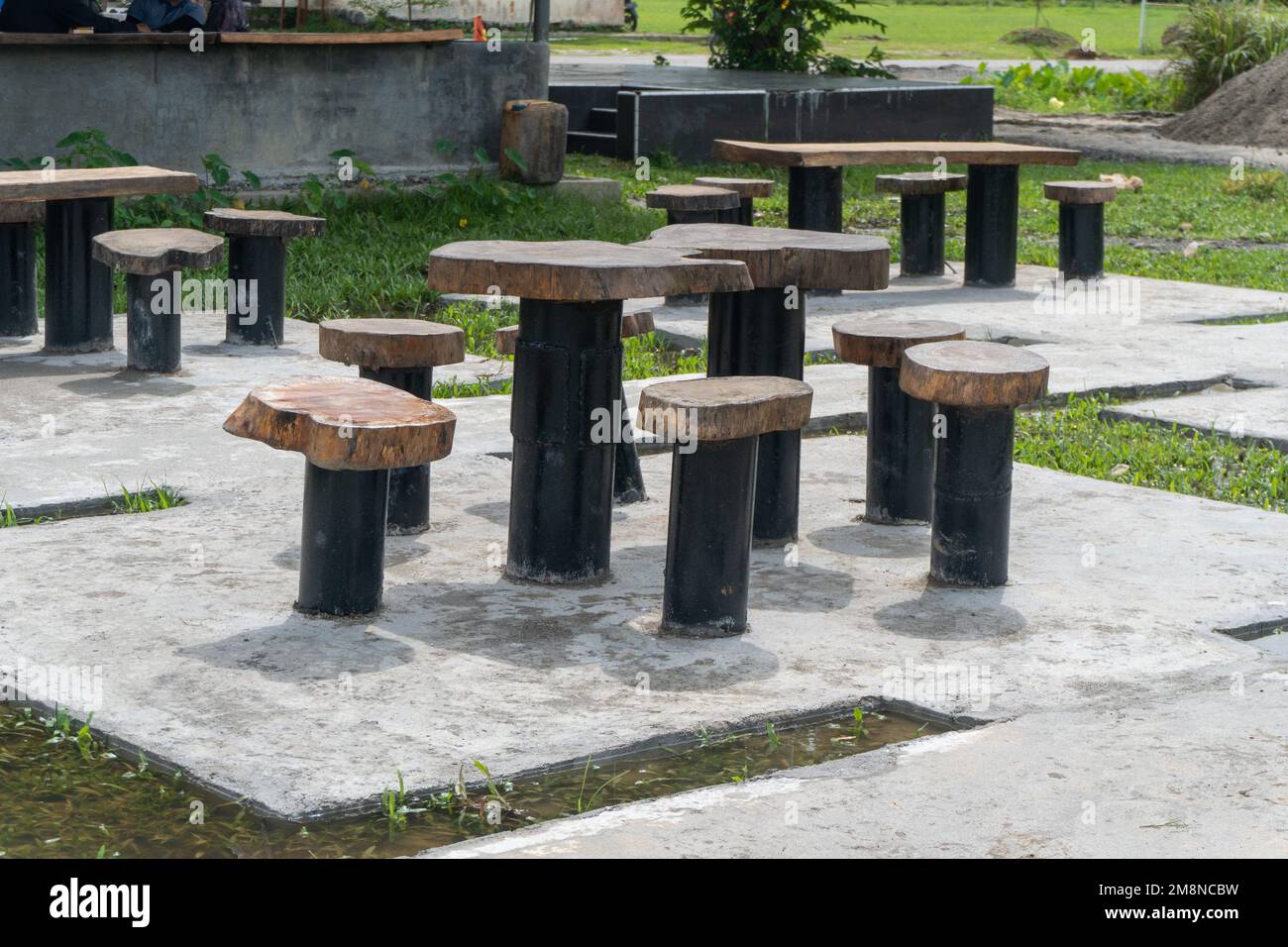 Outdoor cafe with wooden benches in the middle of a city park ...