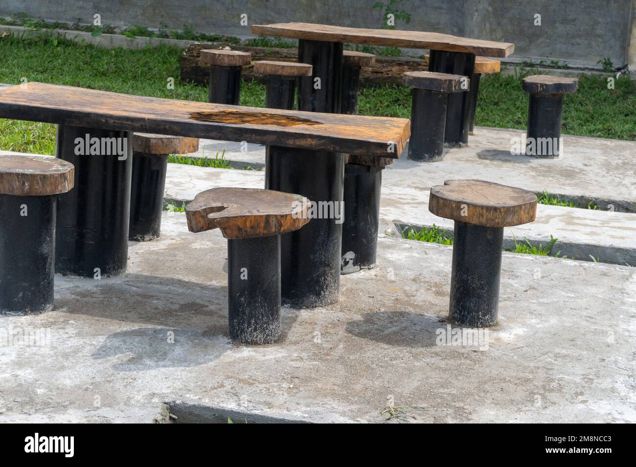 Outdoor cafe with wooden benches in the middle of a city park ...