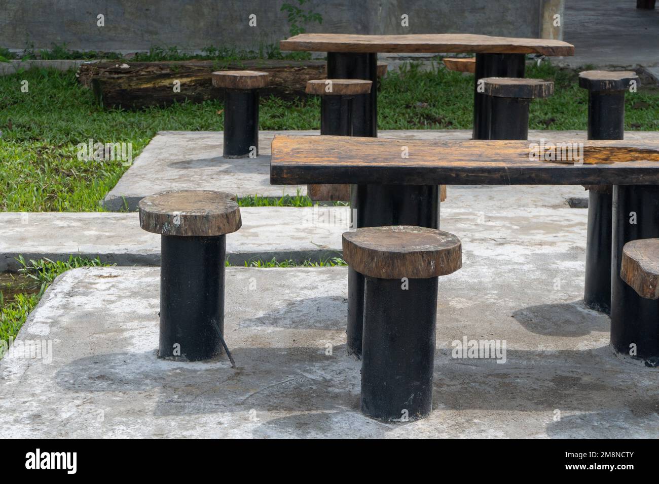 Outdoor cafe with wooden benches in the middle of a city park ...