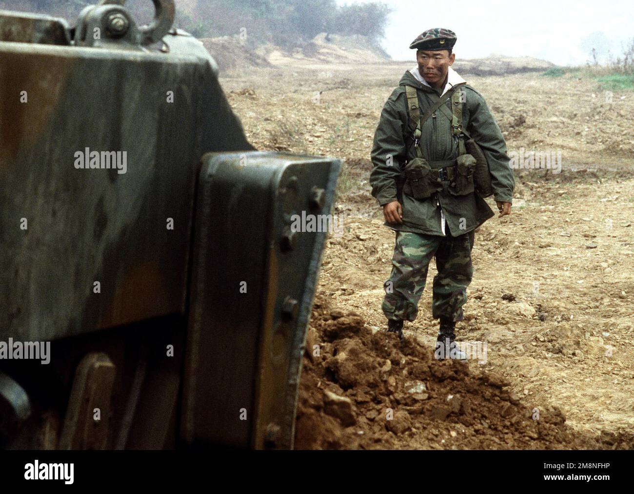 A Republic of Korea Army (ROKA) engineer watches an M-9 Armored Combat ...