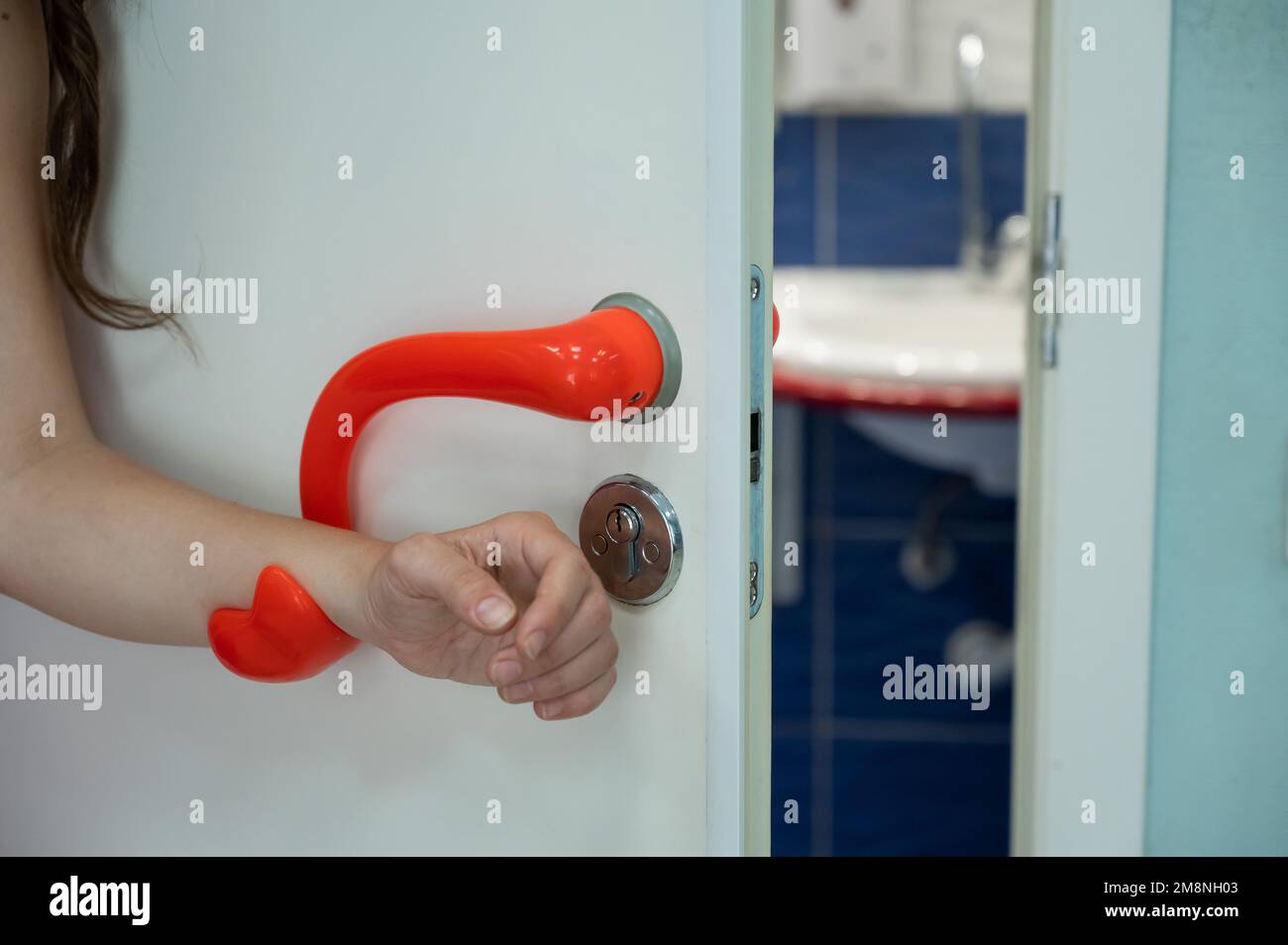 Door handle for people with disabilities. The woman opens the door with ...