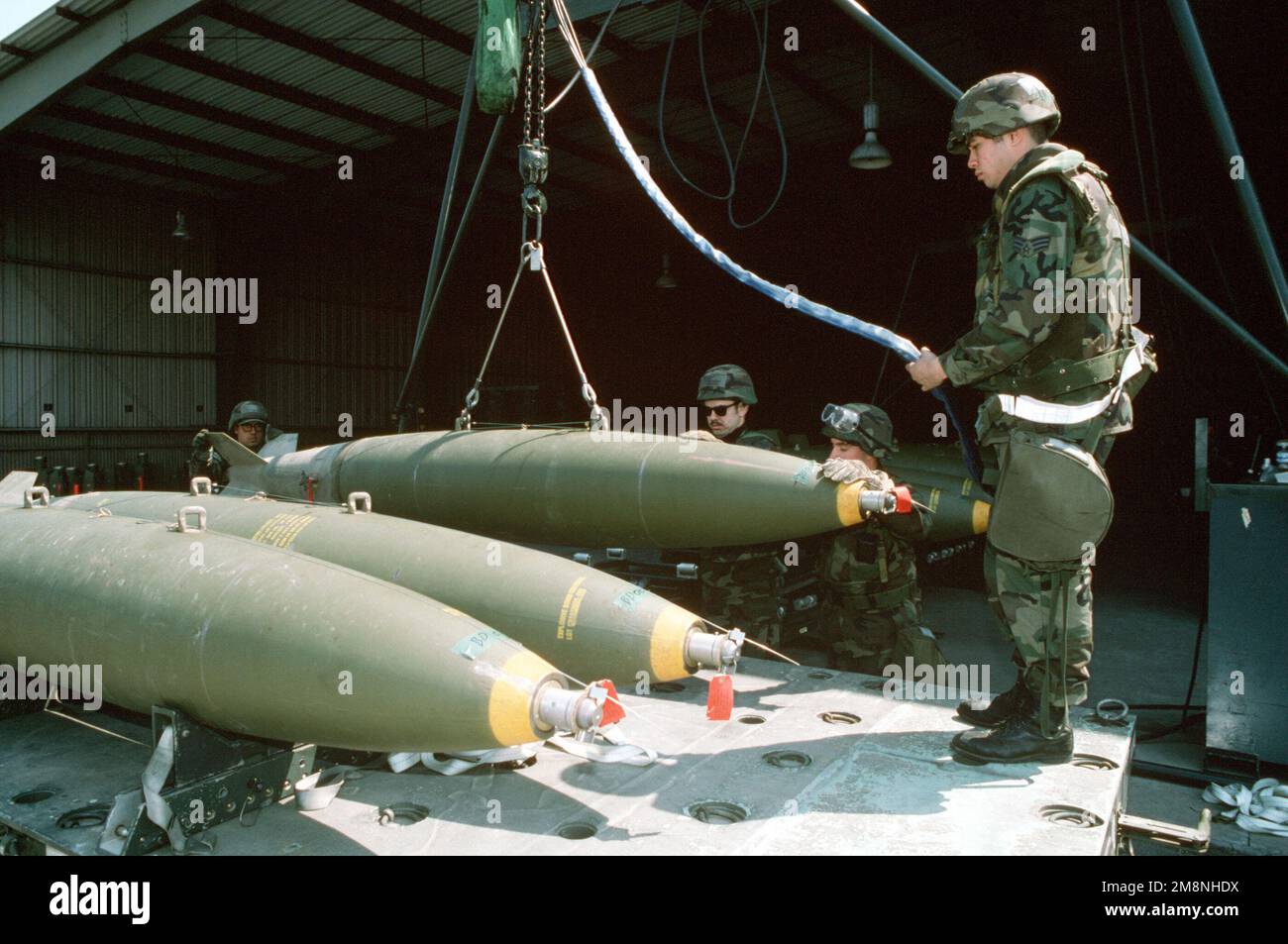 Unidentified USAF Munitions Maintainers load bombs onto a trailer for ...