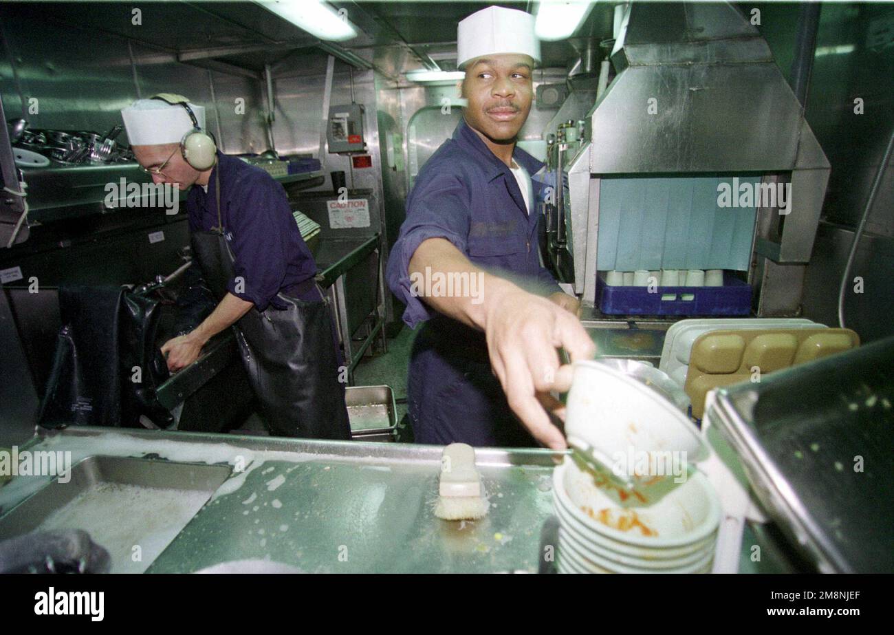 US Navy SEAMAN Charles Bradley grabs the next dish to be washed while ...