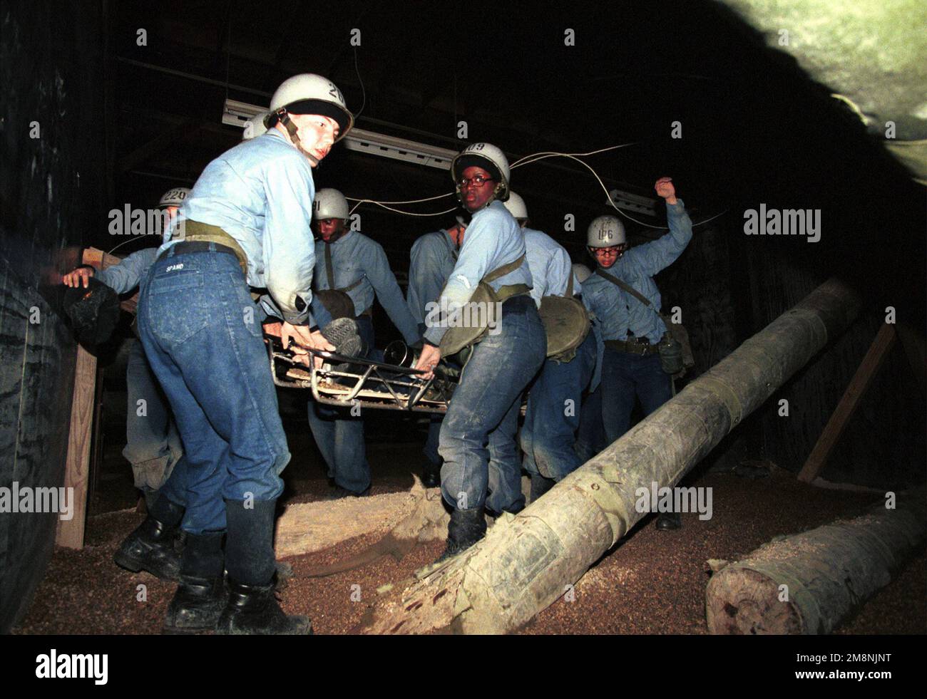 Male and female recruits work together to carry a shipmate in the ...