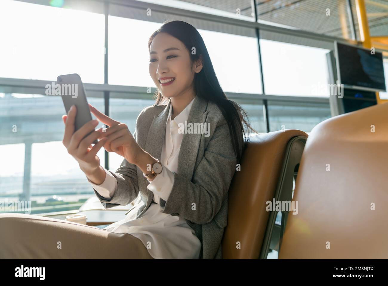 The use of mobile phones business lady in the airport lounge Stock ...