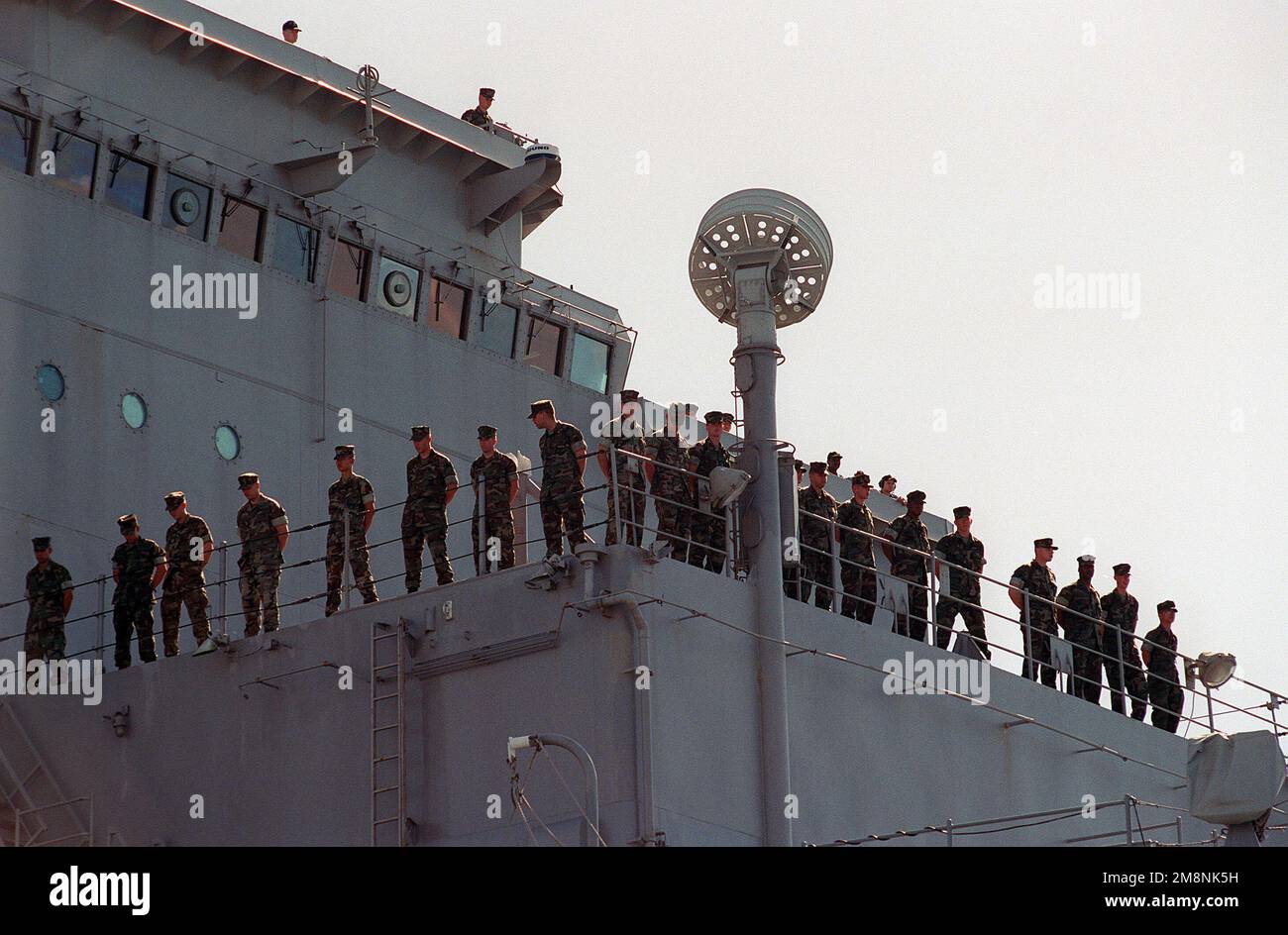 US Marine Corps (USMC) personnel man the rails of the USS FORT MCHENRY ...