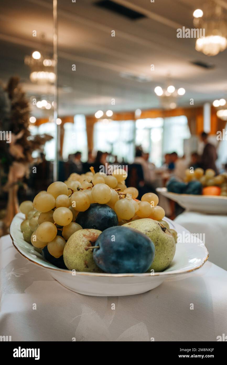 A vertical shot of a bowl full of fruits served on a table in a ...