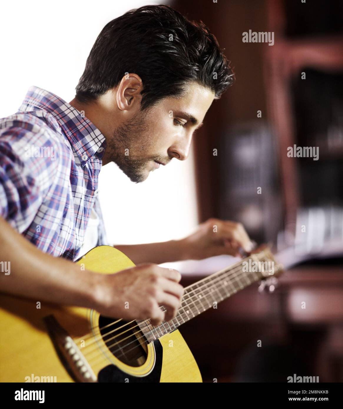 Hip, young and creative. A handsome young musician playing a guitar ...