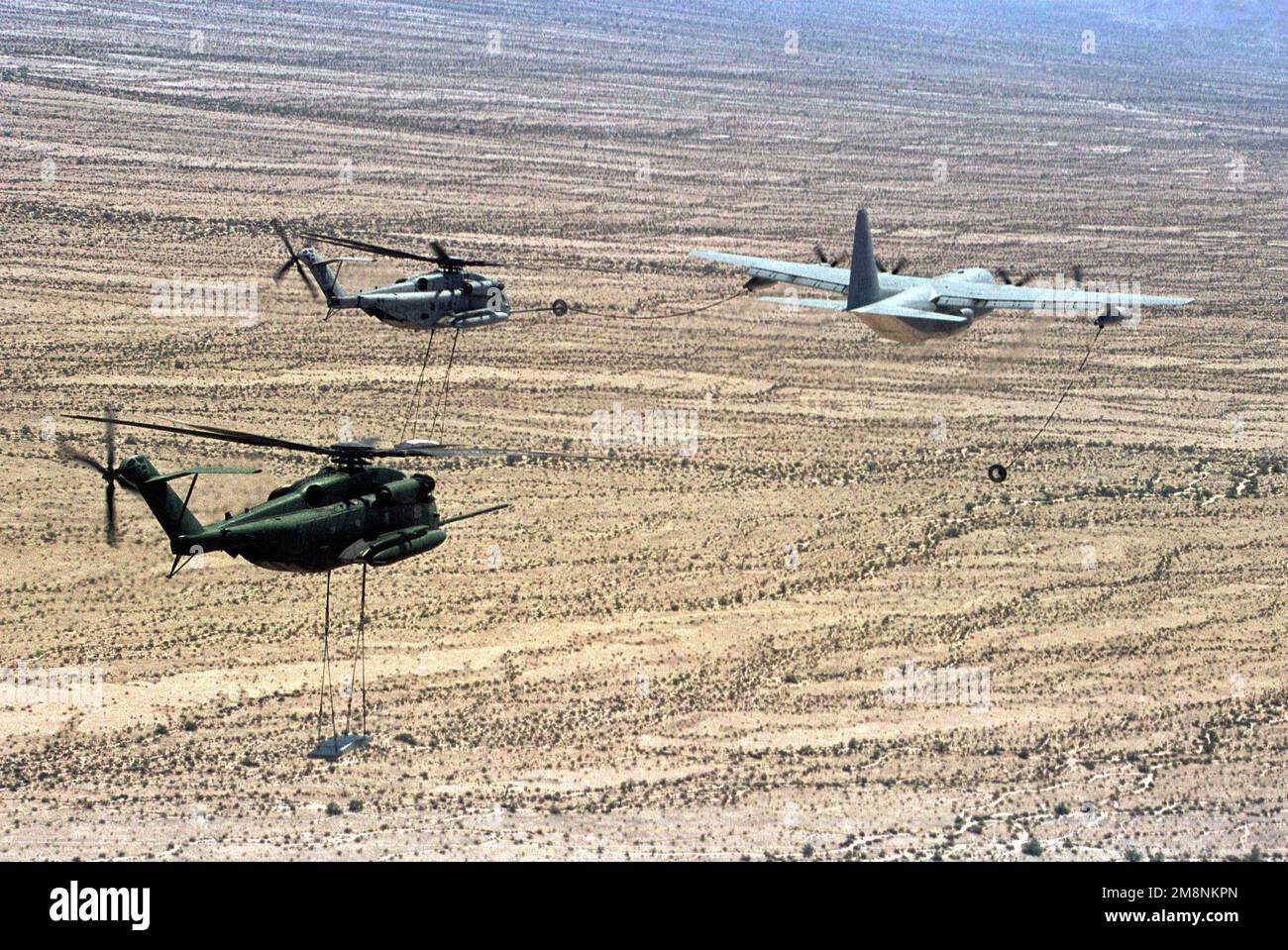 Two Marine CH-53E Sea Stallion helicopters lifting cement slabs ...