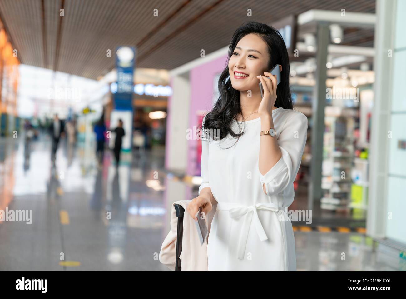 A young woman make a phone call at the airport Stock Photo - Alamy