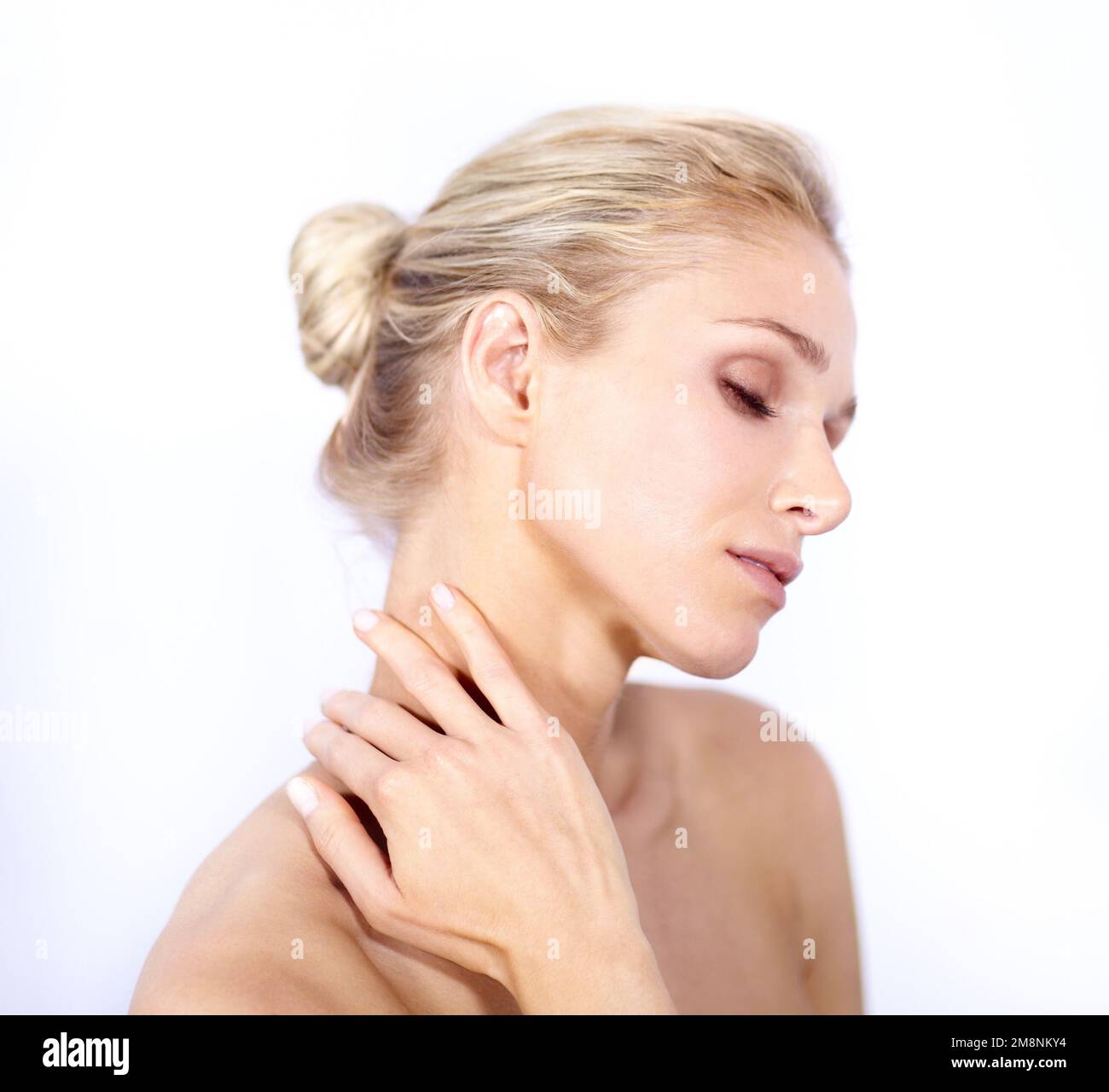 Silky soft touch. Young woman caressing her neck while isolated on ...