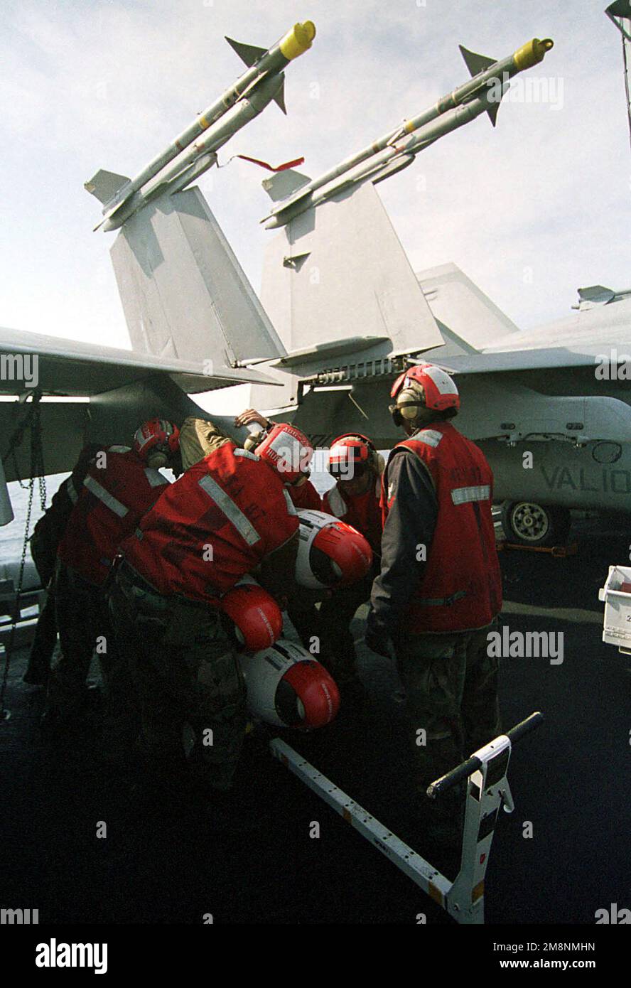 Aviation Ordnancemen load Rockeye cluster bombs on to the wing of an FA ...