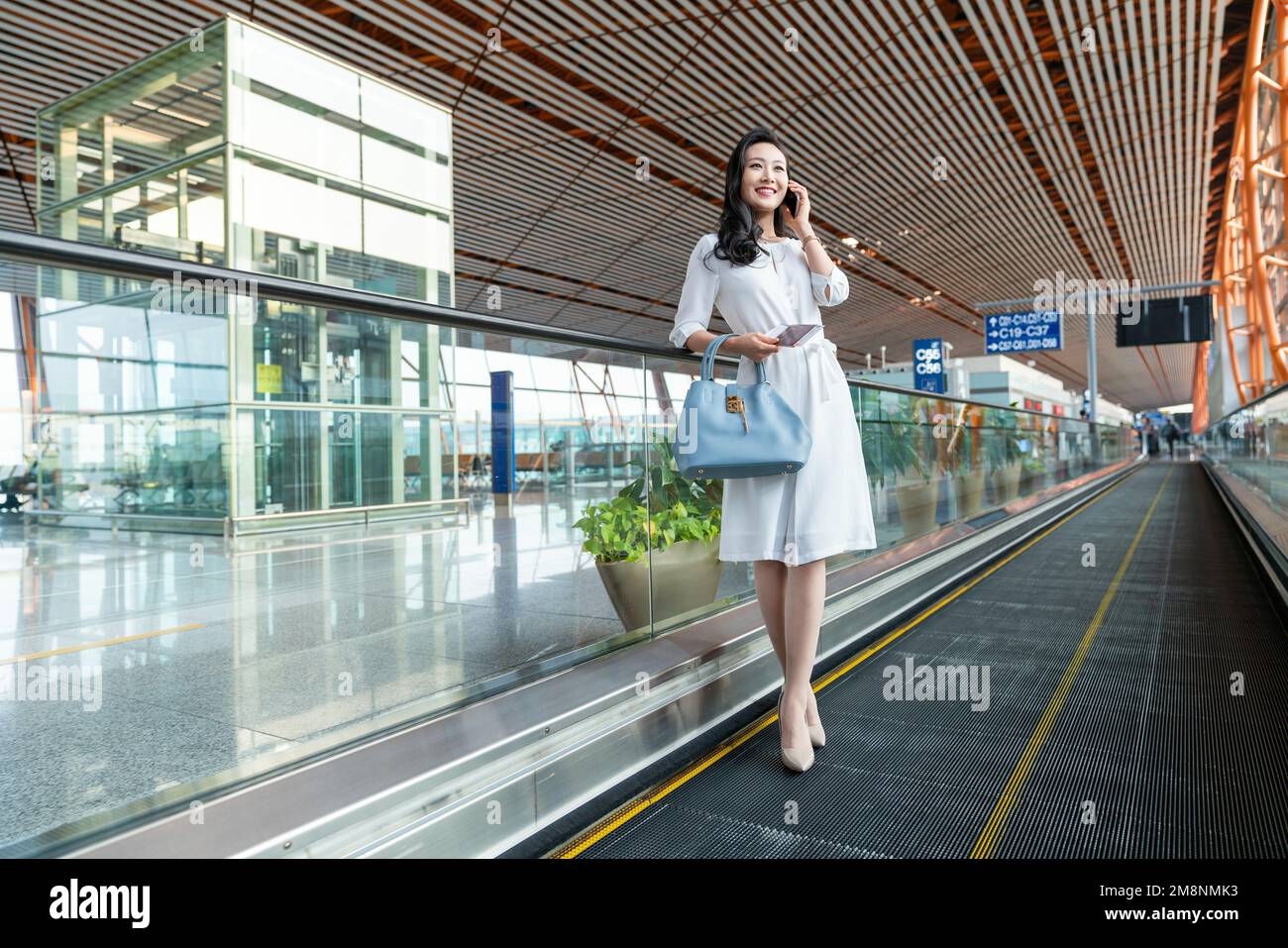 A young woman make a phone call at the airport Stock Photo - Alamy