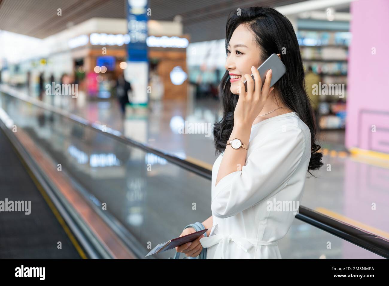 A young woman make a phone call at the airport Stock Photo - Alamy