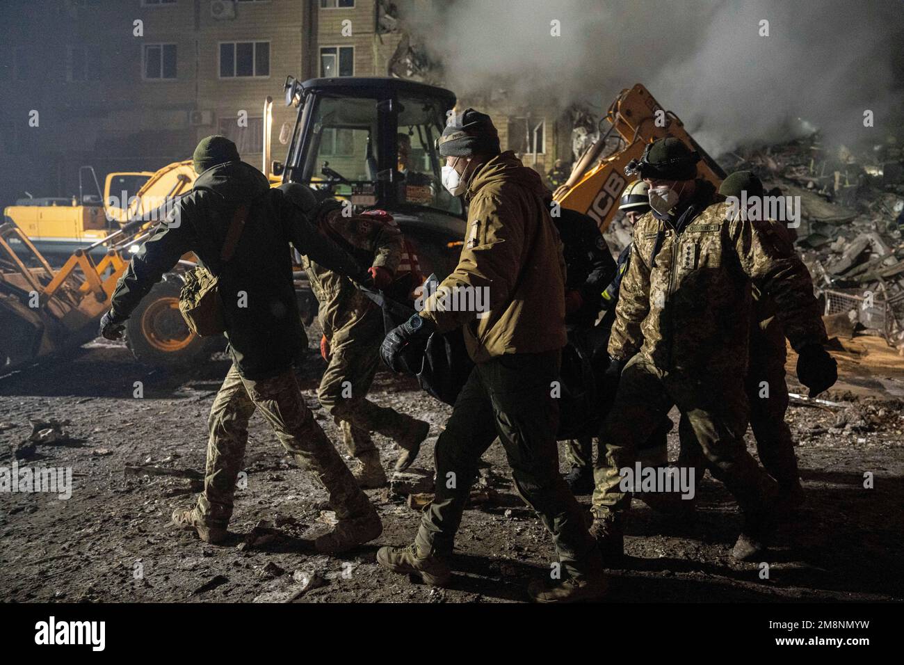 Ukrainian servicemen carry a body of a man who was killed by a Russian ...