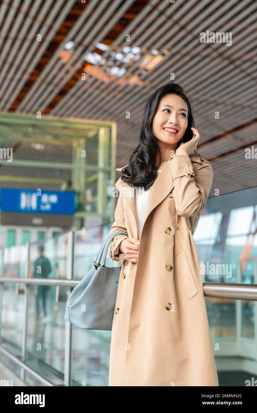 A young woman make a phone call at the airport Stock Photo - Alamy