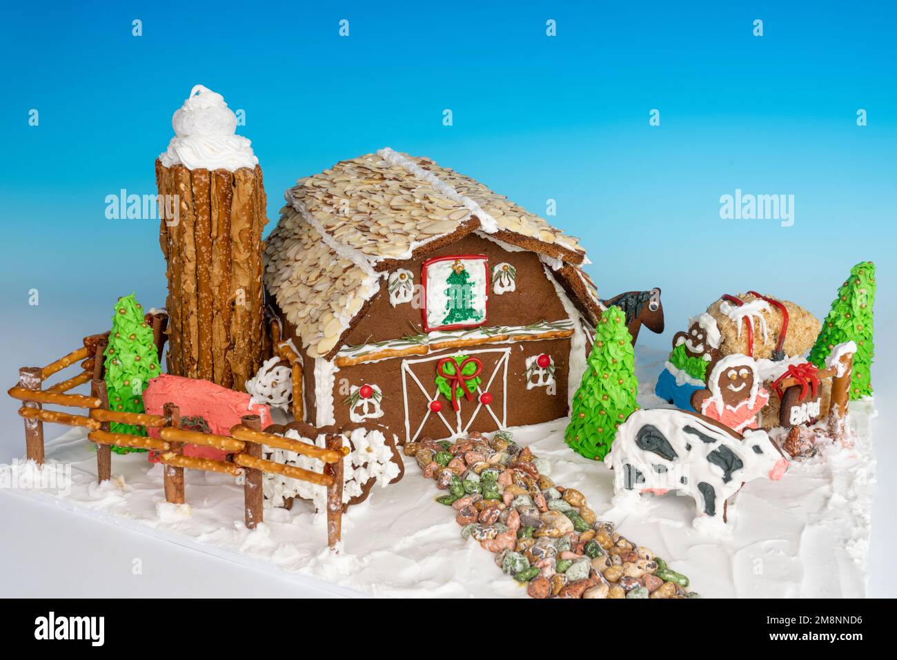 Front side of a homemade gingerbread barn with silo, farm animals, girl ...