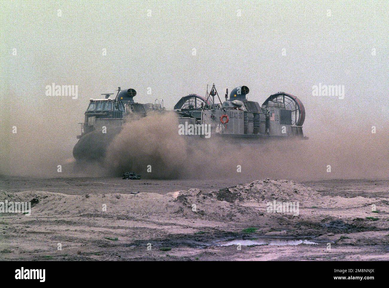 A US Navy Landing Craft Air Cushion (LCAC-90) lands on shore at Camp ...