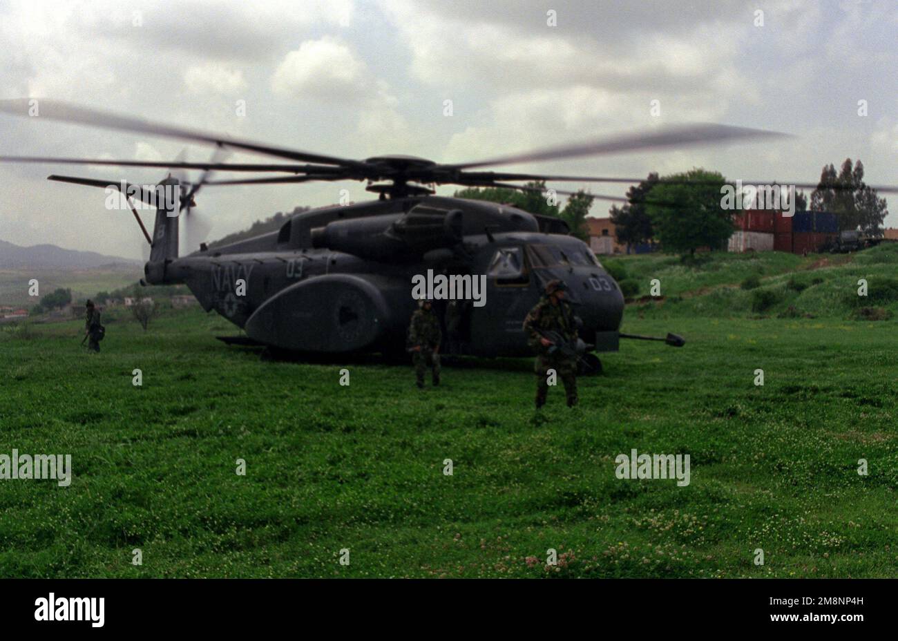 An MH-53E from HM-15 guarded by Marines awaits Adm. Ellis (not shown ...