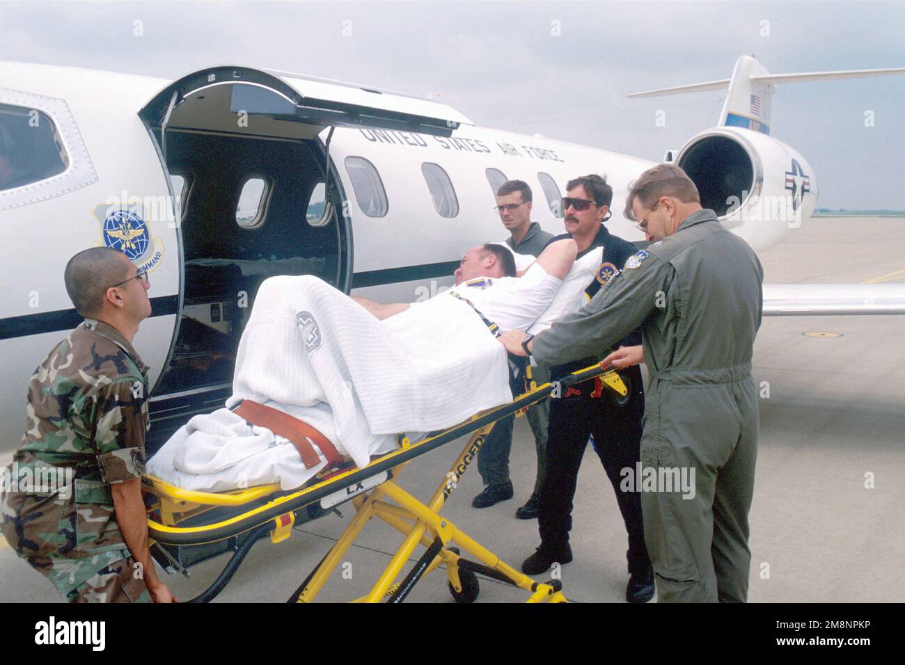 Aircrew and emergency medical technicians load Allen aboard the C-21 at ...